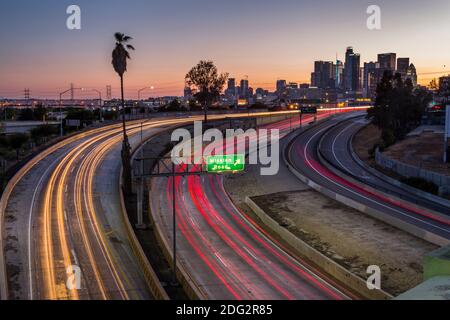 View of Downtown LA and freeway trail lights at sunset, Los Angeles ...