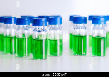 HPLC vials with green sample of plant extracts. Developing of drugs ...