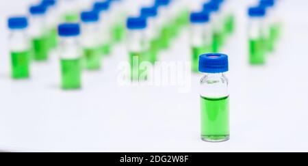 HPLC vials with green sample of plant extracts. Developing of drugs ...