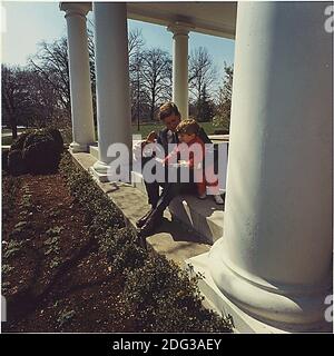 John F. Kennedy, Jr., plays with his dog, Shannon, at Brambletyde house ...