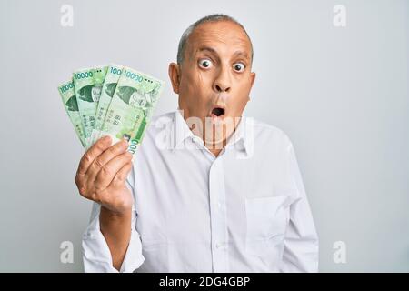 Handsome senior man holding 10000 south korean won banknotes doing ok ...