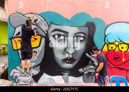 Malaysian street artist Kenji Chai doing a wall mural in Kuala Lumpur ...