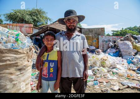 Osman Gony (10) is sorting plastic bottles with his father Muhammad ...