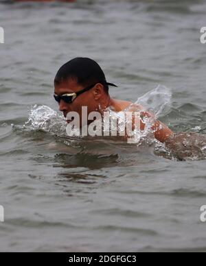 Despite the cold weather, more than a thousand swimmers swim across the ...