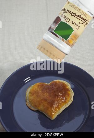 Sprinkled icing sugar over cake decorations and small wooden Christmas ...