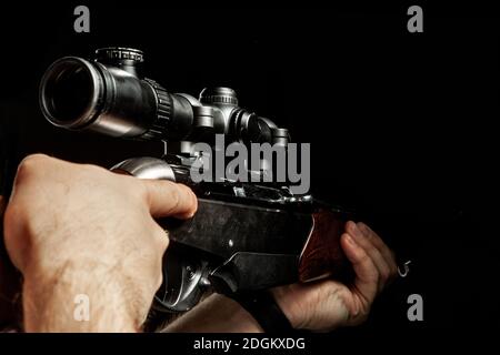 Male hands holding hunting rifle on black background Stock Photo - Alamy
