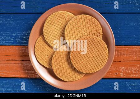 Round waffles with caramel in ceramic plate on old wooden table Stock ...