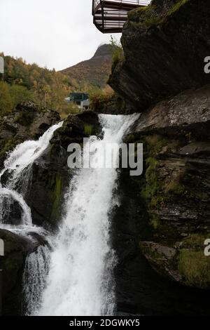Powerful waterfall cascading down a steep cliff side with lush green ...
