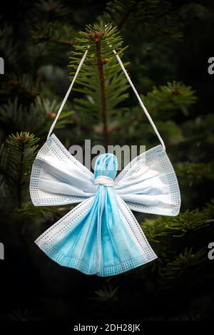 blue medical mask with christmas tree-shaped clothespins. new years ...