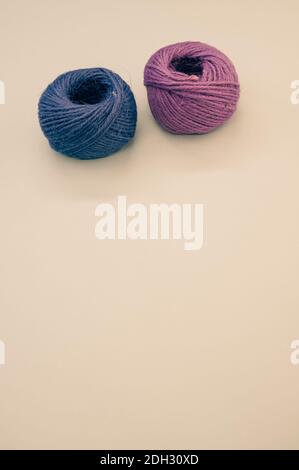 A vertical shot of blue and beige yarns isolated on a beige background ...
