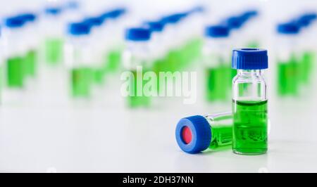 HPLC vials with green sample of plant extracts. Developing of drugs ...