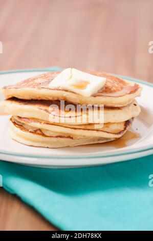 Stack of hot pancakes with melting honey on white plate with orange ...