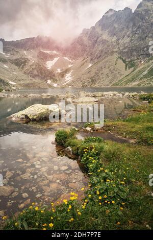 Lake with clouds reflected with High Tatras Mountains at dawn ...