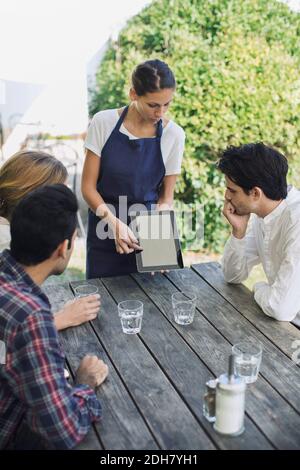 waitress showing a menu Stock Photo - Alamy