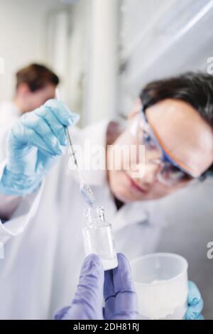 Two Female Scientist Examine Sample Working In Modern Laboratory, Group ...