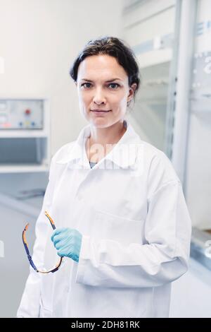Person standing in Laboratory holding Autoclave Sterilizer metal box ...