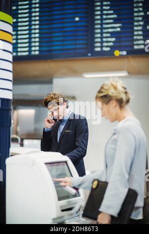 Businesswoman using ticket machine at the airport Stock Photo - Alamy