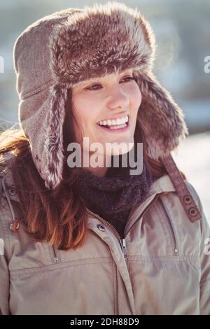 Happy woman looking away while standing on city street Stock Photo - Alamy