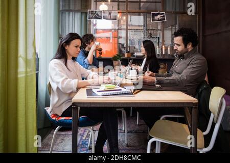 Business people sitting at the table and working with documents and ...