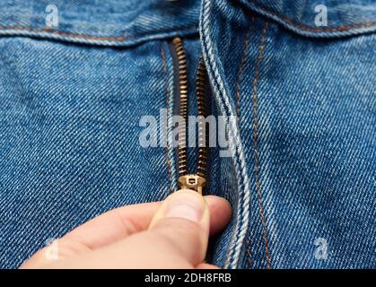 female hand unzips jeans zipper close up Stock Photo - Alamy