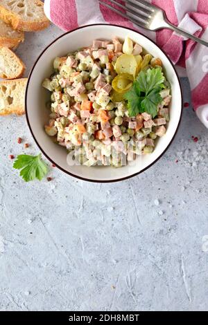 Homemade Russian salad or Olivier from boiled vegetables and sausage in ...