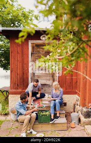 Friends sitting on steps outside building Stock Photo - Alamy