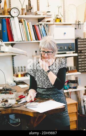 Woman using calculator working on laptop at home Stock Photo - Alamy