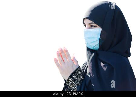 woman in veil and medical mask looking at camera while leaning on groom ...