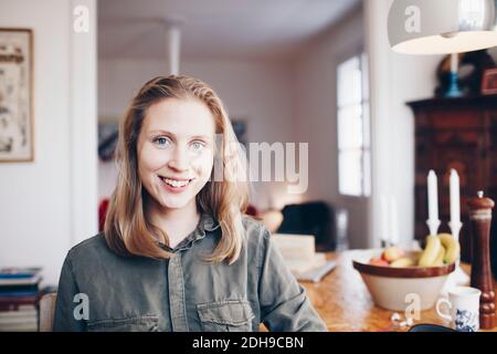 Young woman on home table talks on smartphone explaining details and ...