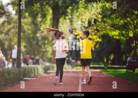 Two teenagers boy and girl doing fitness workout with weights isolated ...