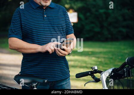 Midsection of man using mobile phone Stock Photo - Alamy