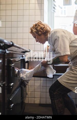 Professional chef using baking oven at his restaurant kitchen Stock ...