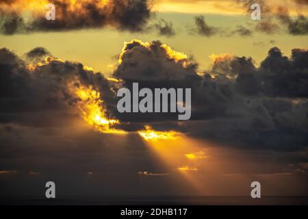 Aerial view of evening sun hiding behind group of dark clouds Stock ...