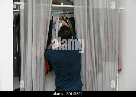 Young hispanic man hanging clothes at clothesline screaming proud ...