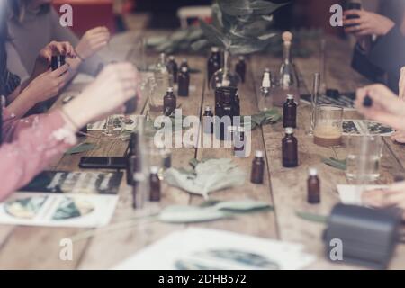 Cropped image of multi-ethnic colleagues standing at table and creating ...