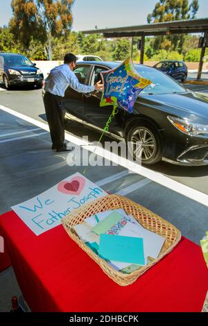 The priest of a Southern California Catholic priest gets a hug from a ...