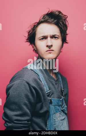Caucasian man standing over pink background pointing aside with hands ...