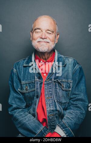 Portrait of smiling man standing by gray wall with arms crossed Stock ...