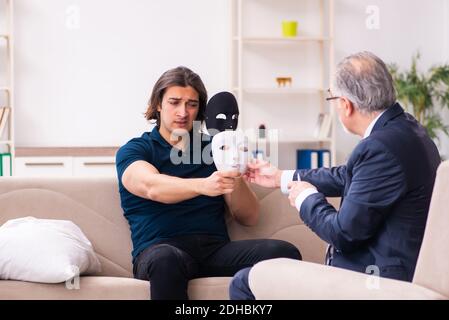 Man wearing masks during psychotherapy session Stock Photo - Alamy