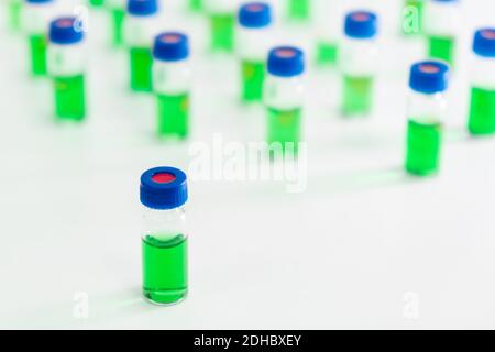 HPLC vials with green sample of plant extracts. Developing of drugs ...