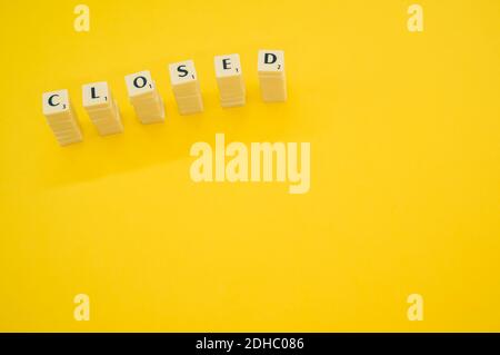 The six white letter block stacks forming the word CLOSED on yellow ...