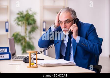 Old businessman employee in time management concept Stock Photo - Alamy