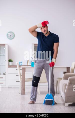 Young leg injured contractor cleaning house Stock Photo - Alamy
