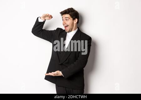 Portrait of an excited man standing over red background, looking at ...