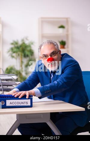 Old businessman clown working in the office Stock Photo - Alamy