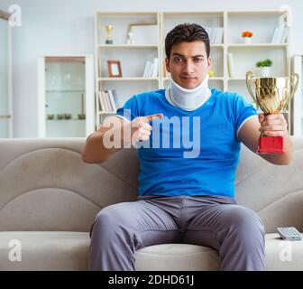 Man with neck injury watching football soccer at home Stock Photo - Alamy