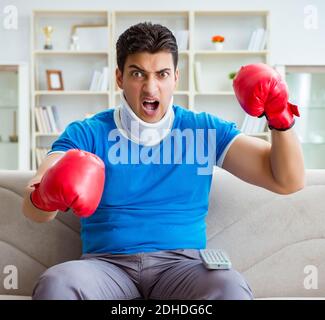 Man with neck injury watching boxing at home Stock Photo - Alamy