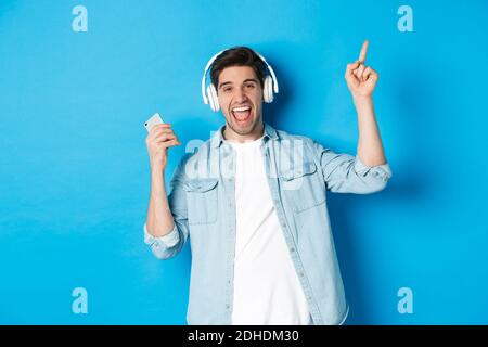 Handsome brunette pointing at his gadget Stock Photo - Alamy