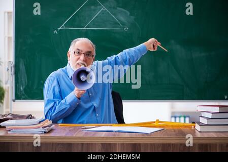 Angry aged male math teacher holding megaphone Stock Photo - Alamy