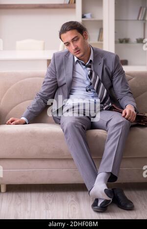 Tired businessman coming home after working day Stock Photo - Alamy